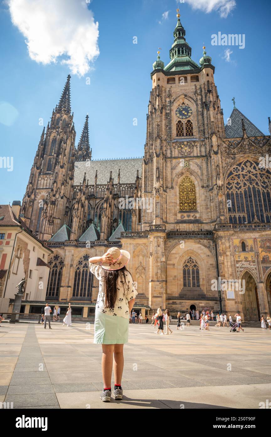 A beautiful woman in front of St. Vitus Cathedral at Prague Castle in ...