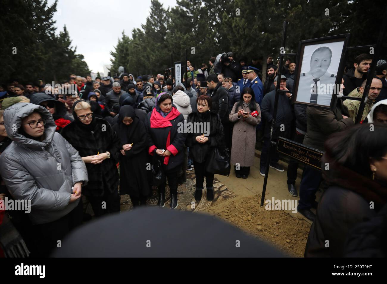 People stand at the grave of pilot in command Igor Kshnyakin during a ...