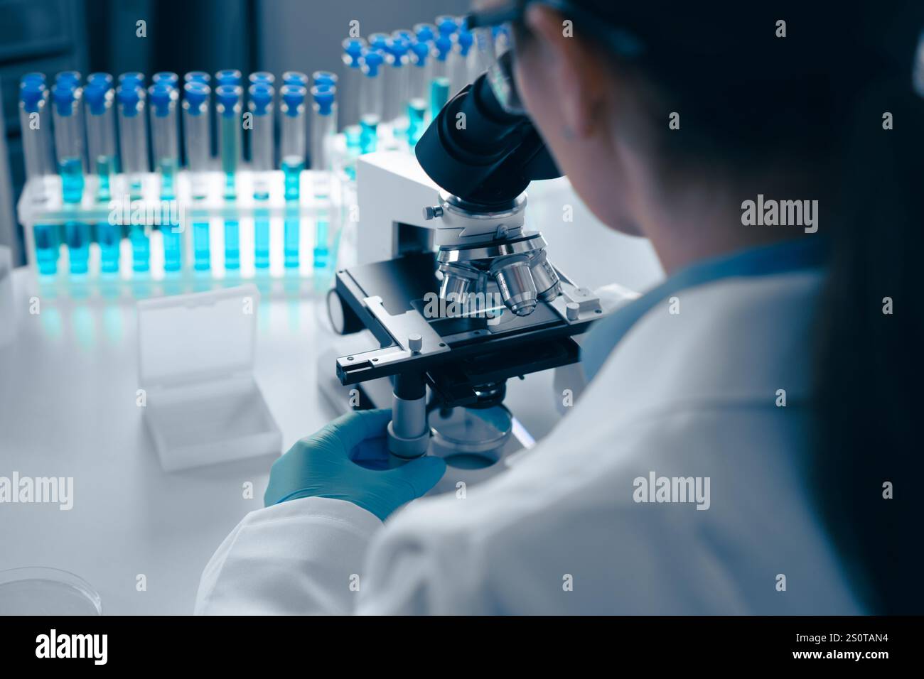 A scientist is meticulously examining various samples under a ...