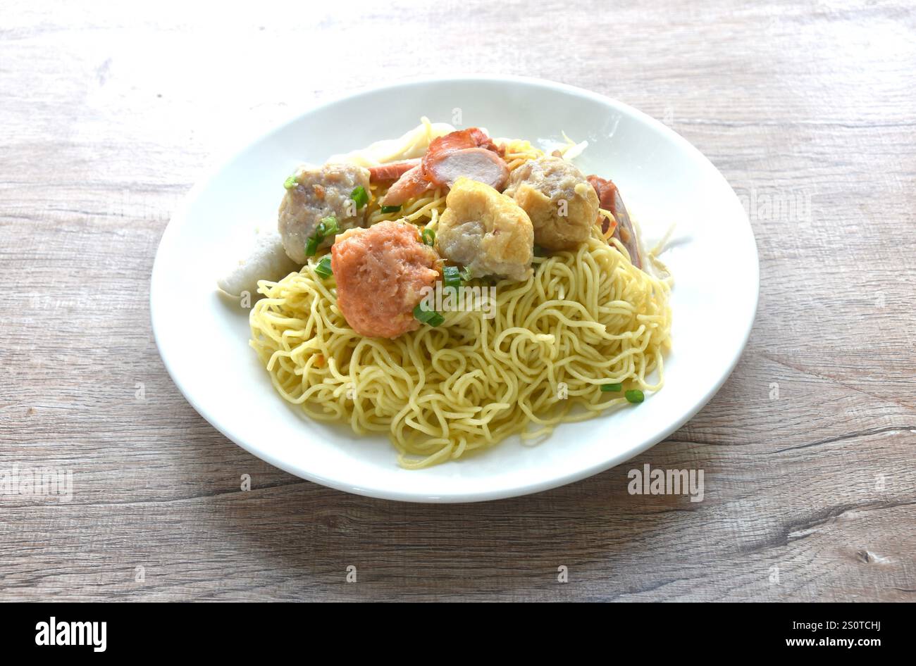 dry Chinese yellow egg noodles topping steamed Hakka meatball made from ...