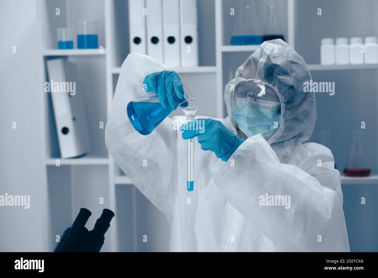 A meticulous scientist in protective gear is conducting a complex ...