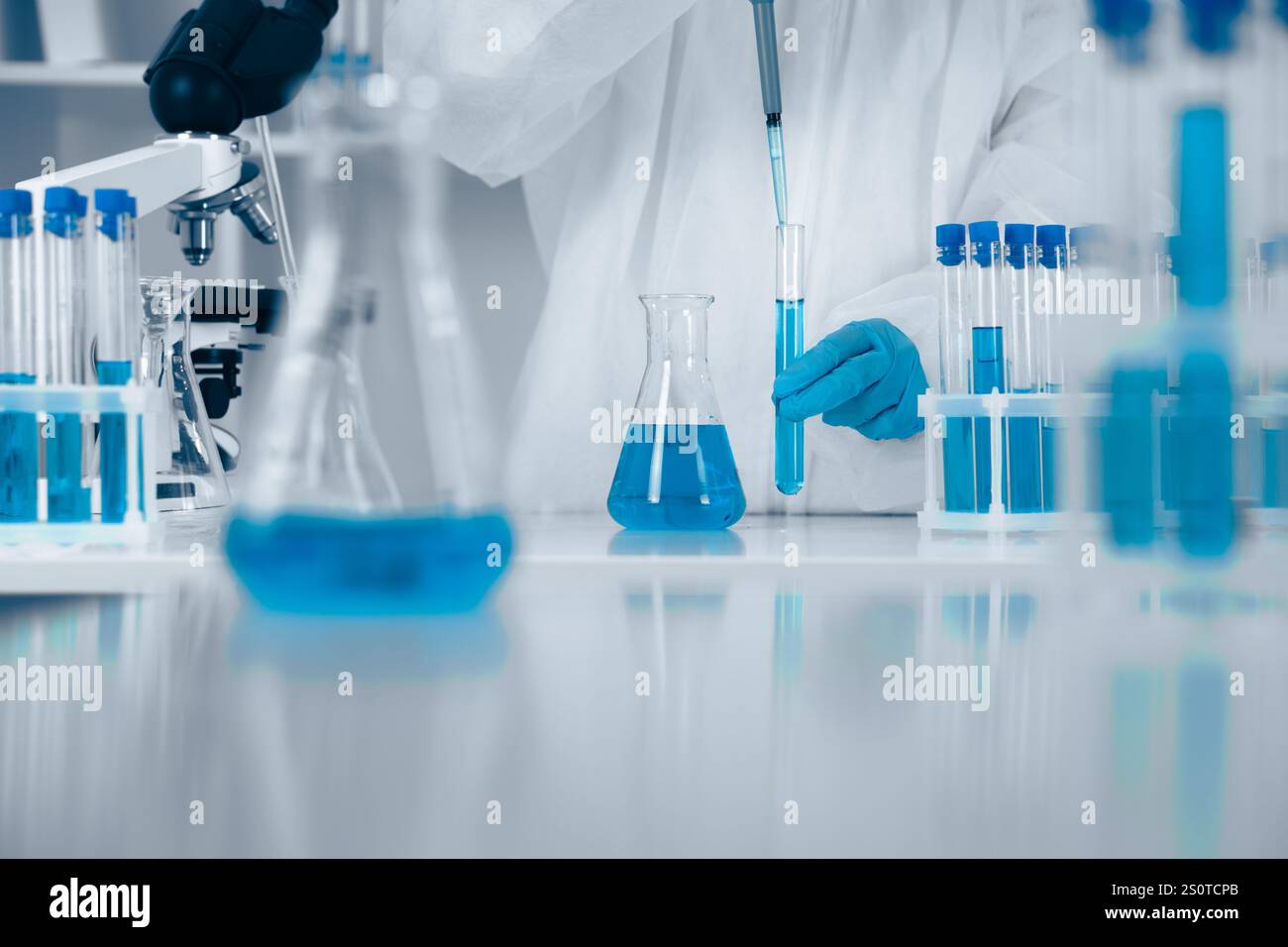 A dedicated scientist conducts experiments with blue solutions ...