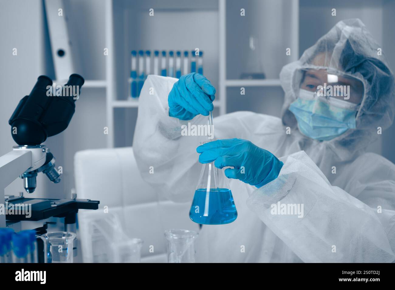 A dedicated scientist is engaged in conducting a meticulous laboratory experiment using a ...