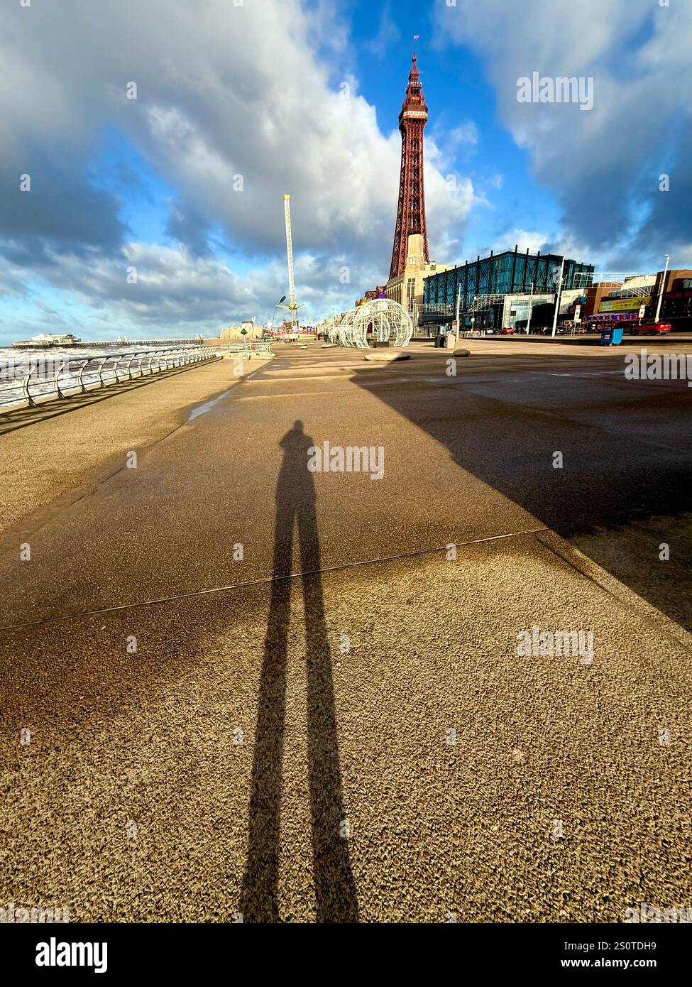 Long shadow of photographer leading along Blackpool central promenade ...