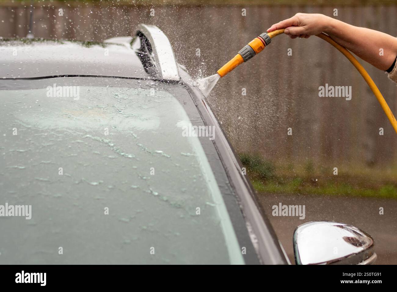 Washing a car with a hose pipe Stock Photo - Alamy