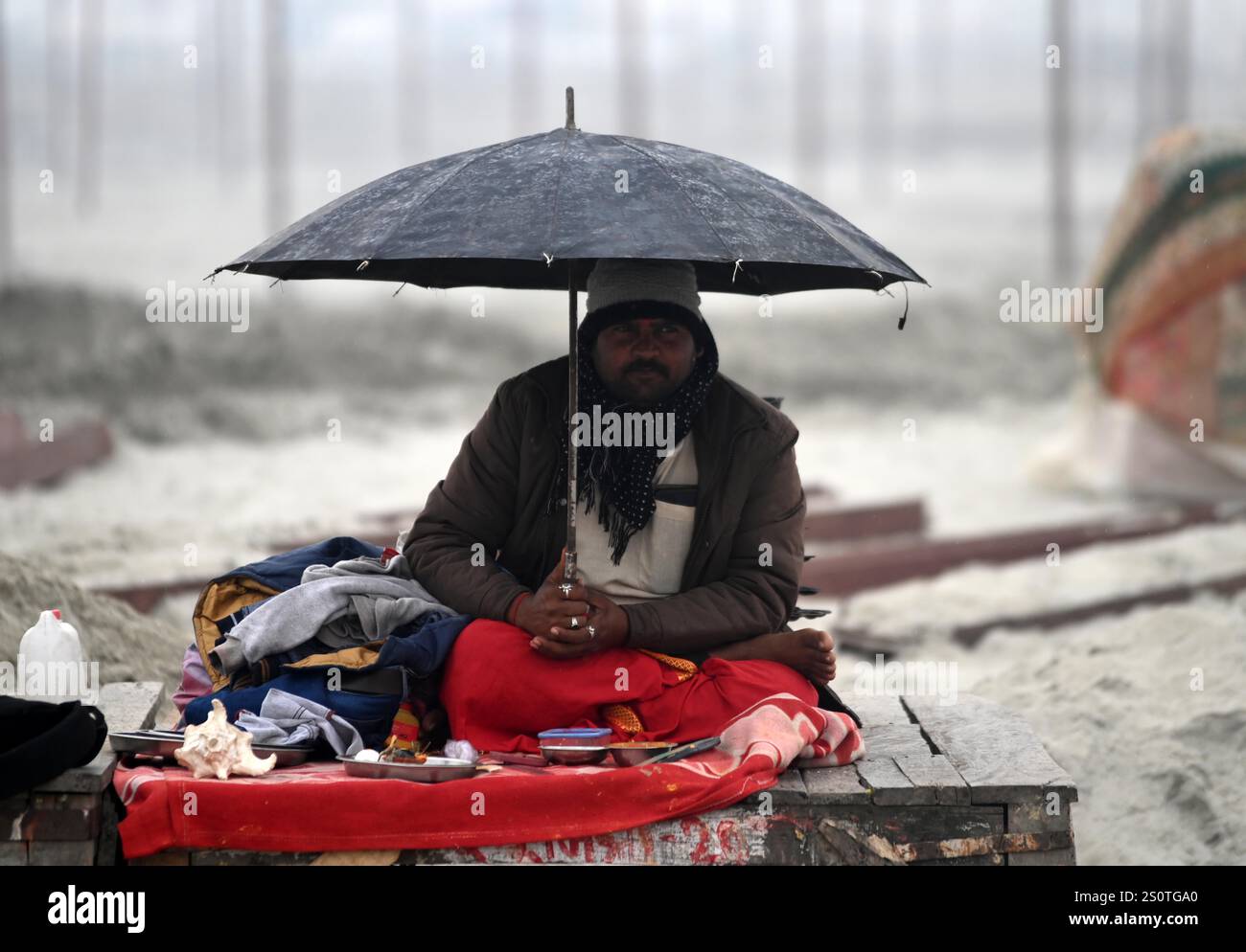 Prayagraj, India. 27th Dec, 2024. Prayagraj: A Local brahmin wrapped in ...