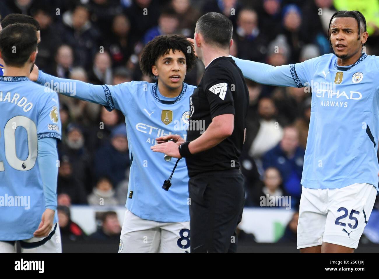 Referee Michael Oliver, center, discusses with Manchester City's Rico ...