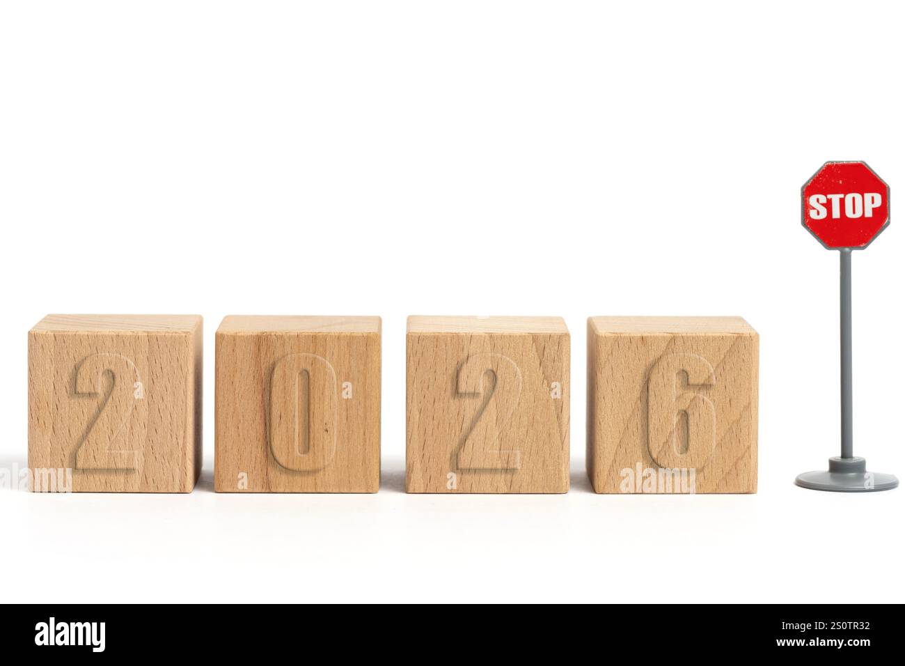 Wooden blocks display number 2026 alongside a red STOP sign, representing transition or alert ...