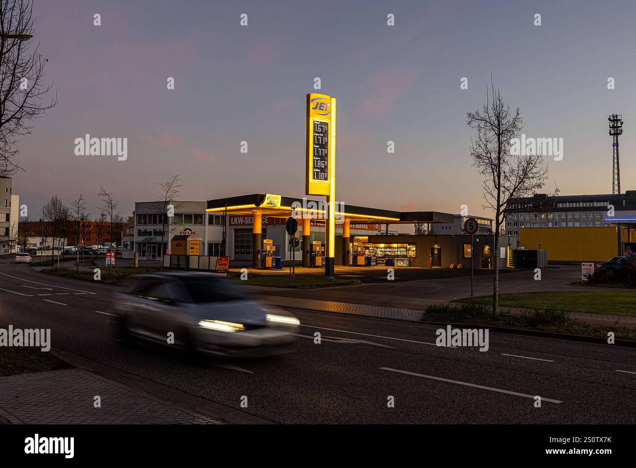 Ein Auto fährt auf einer Strasse vor einer Tankstelle der Marke JET ...