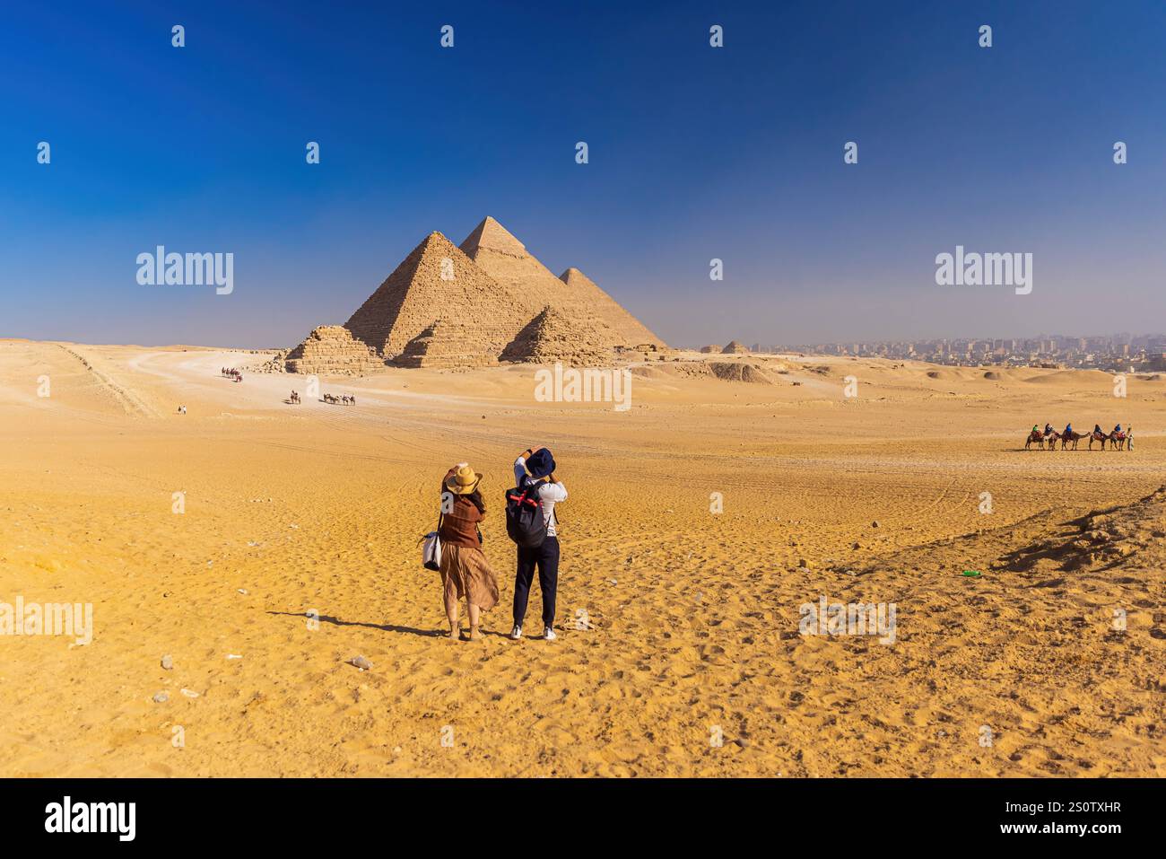 GIZA, EGYPT - DECEMBER 23, 2024: Tourist couple taking pictures of the ...