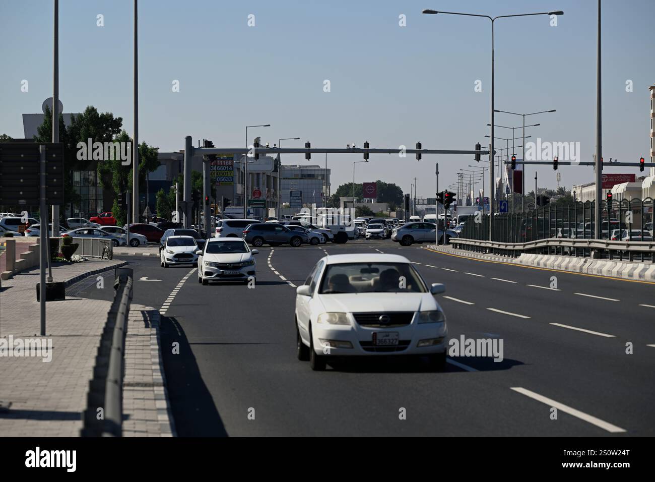 Traffic on a main street in downtown Doha, Qatar on a Sunday morning ...