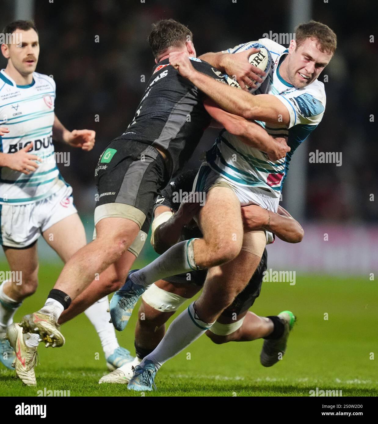 Gloucester's Max Llewellyn is tackled by Exeter's Greg Fisilau and Dan ...