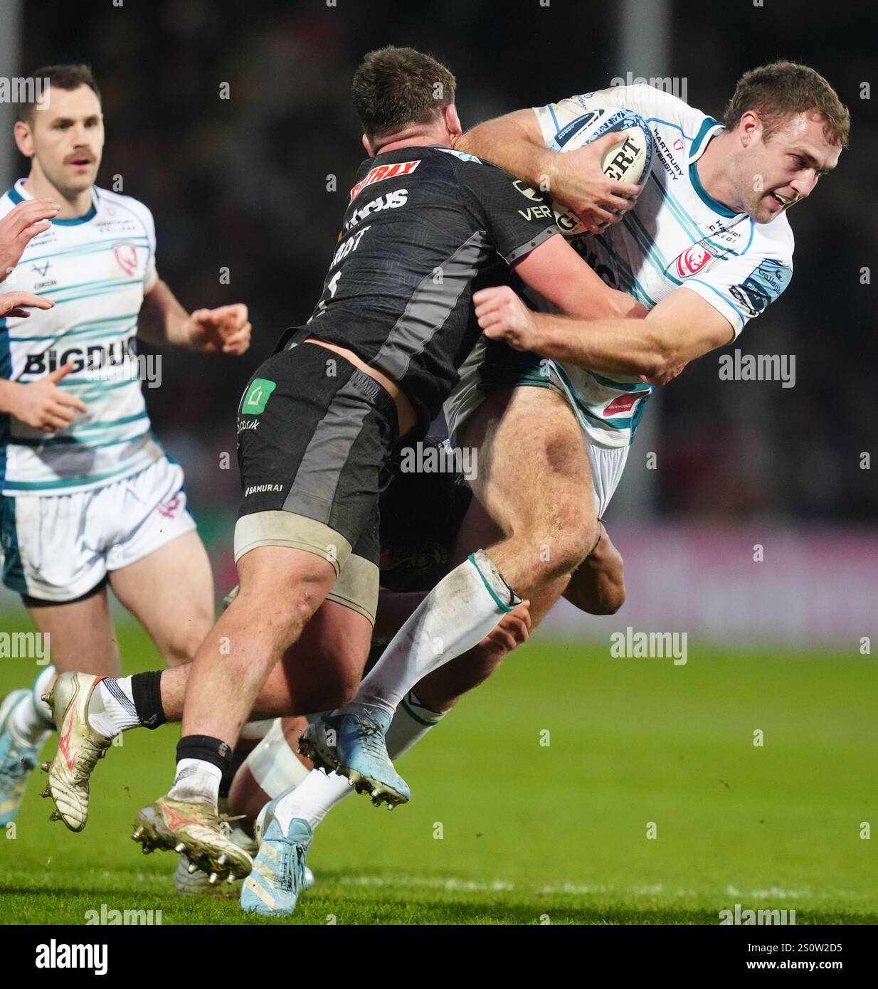 Gloucester's Max Llewellyn is tackled by Exeter's Greg Fisilau and Dan ...