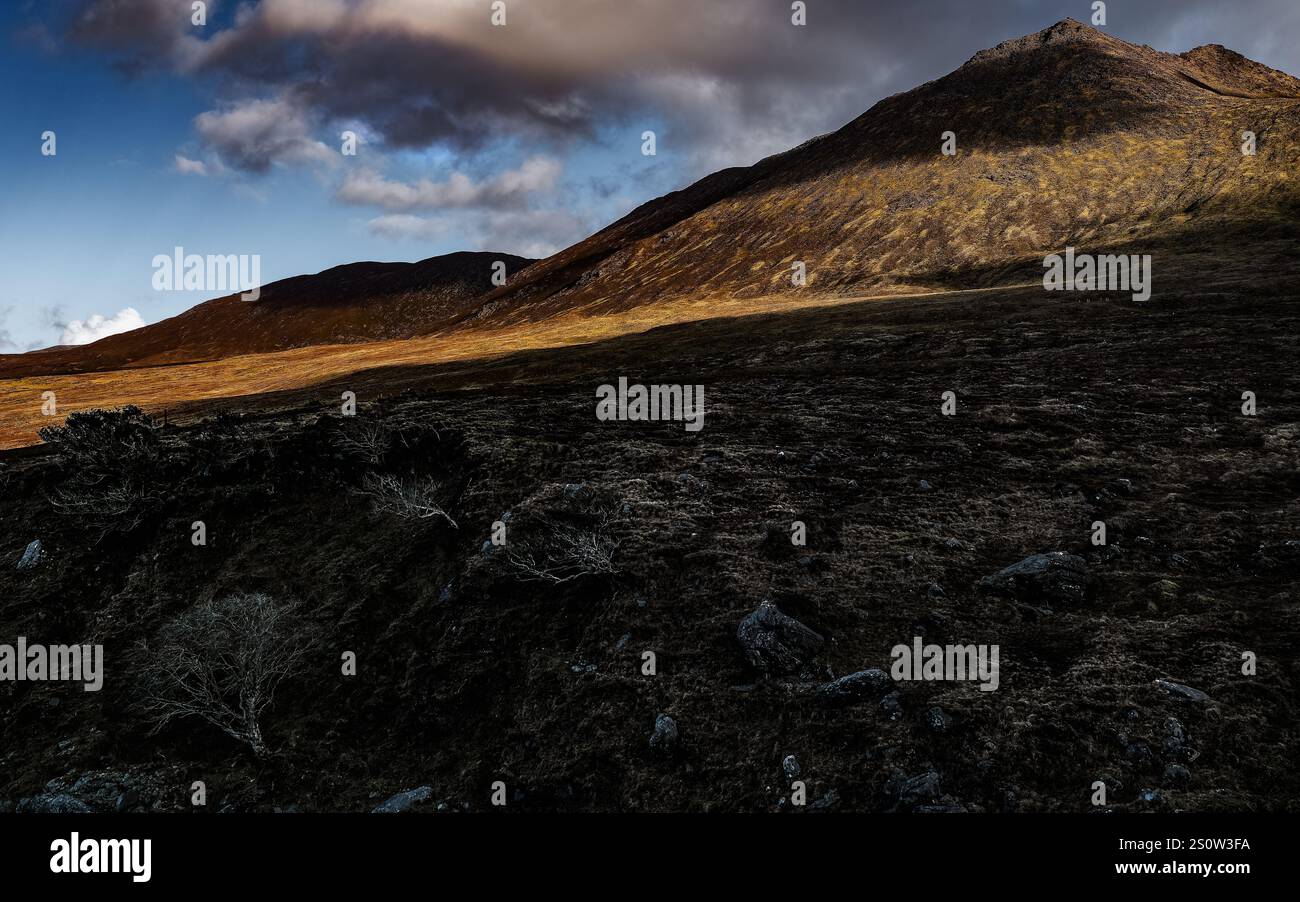 A striking landscape showcases a mountain under changing skies, with ...