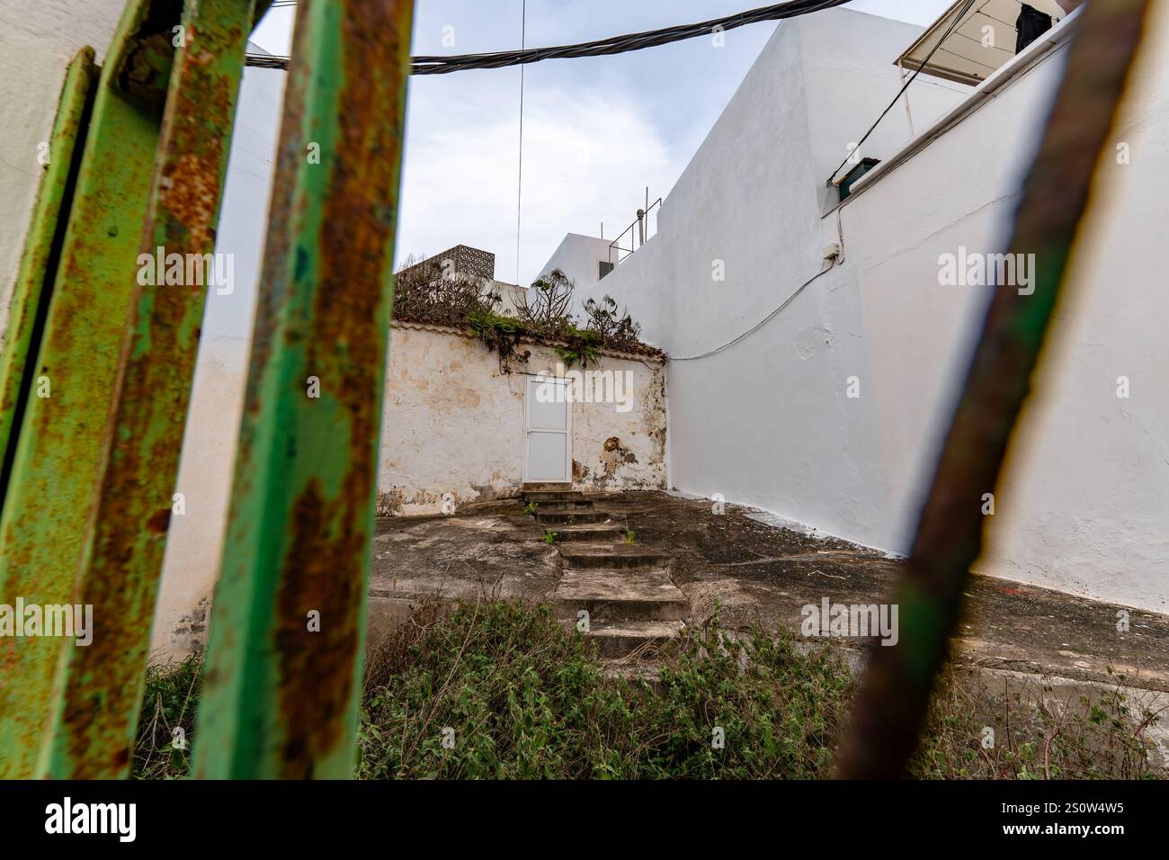 A green fence with a chain link fence behind it. The fence is on the ...