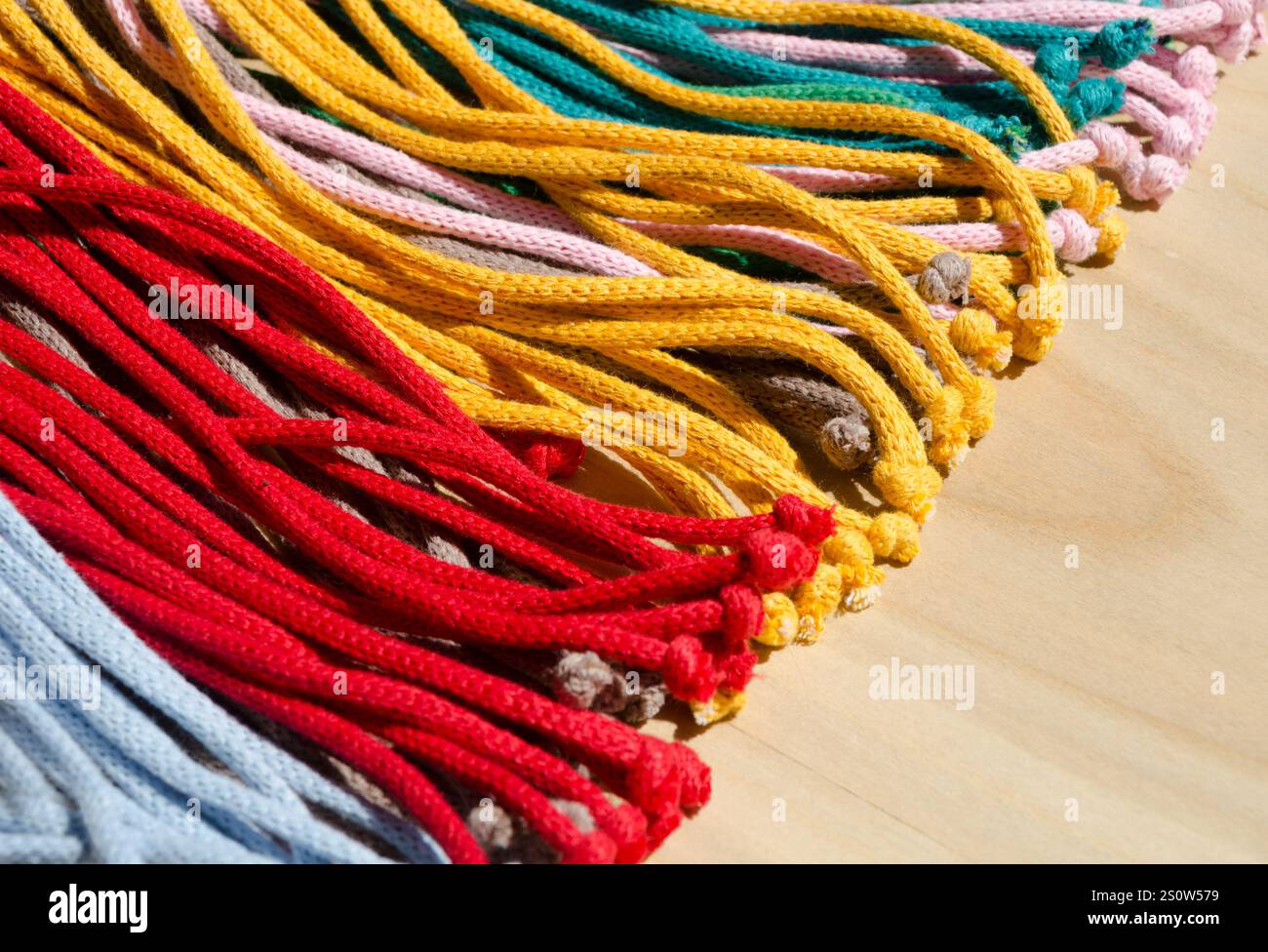 Colorful ropes tied together with knots, ropes for weaving macrame ...