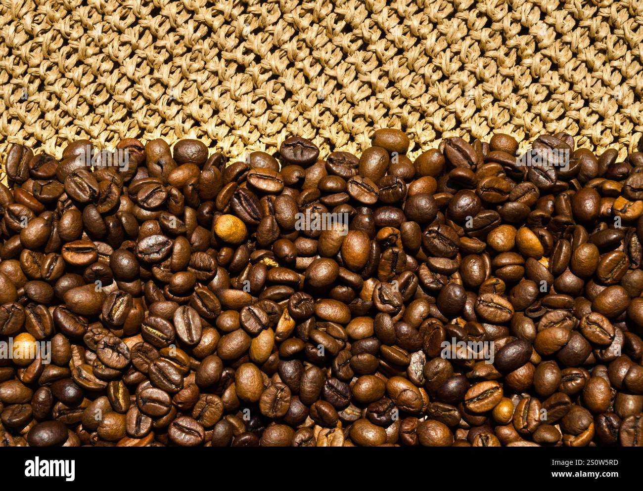 Roasted coffee beans on a knitted pattern in beige raffia. Hand knitted ...