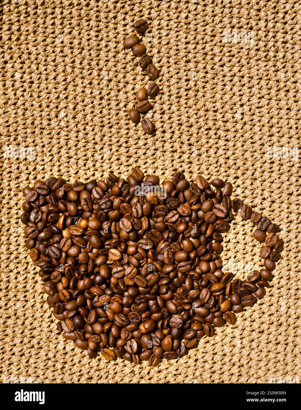 Cup-shaped coffee roasted beans on a knitted pattern in beige raffia ...
