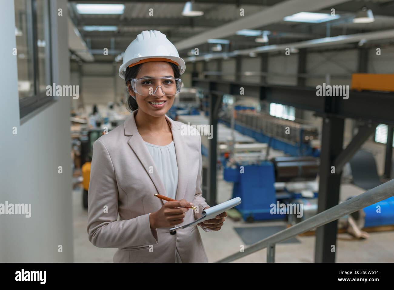 Young Indian woman, a successful metalworking factory manager writing ...