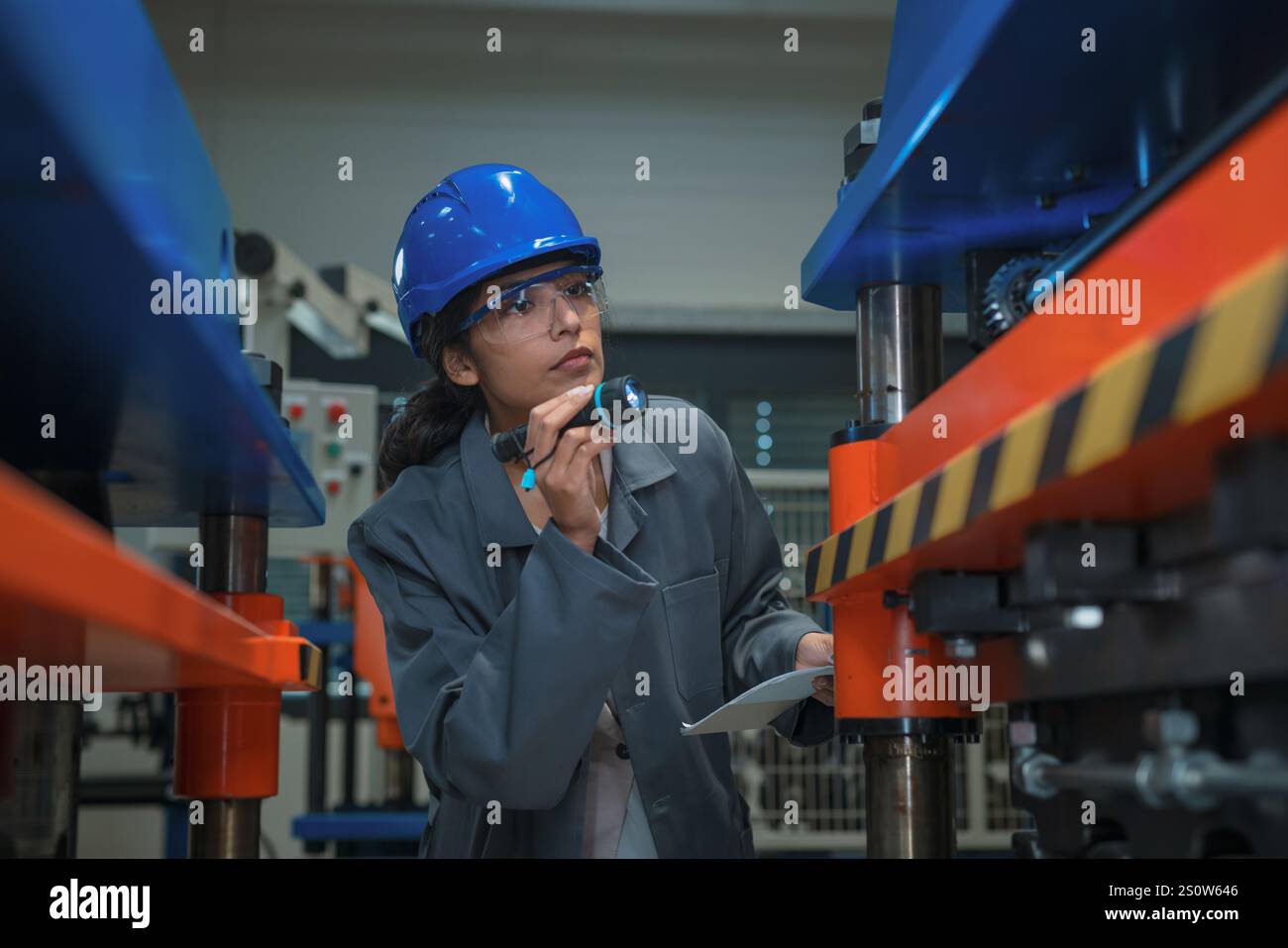 Indian female engineering technology professional holding a flashlight ...