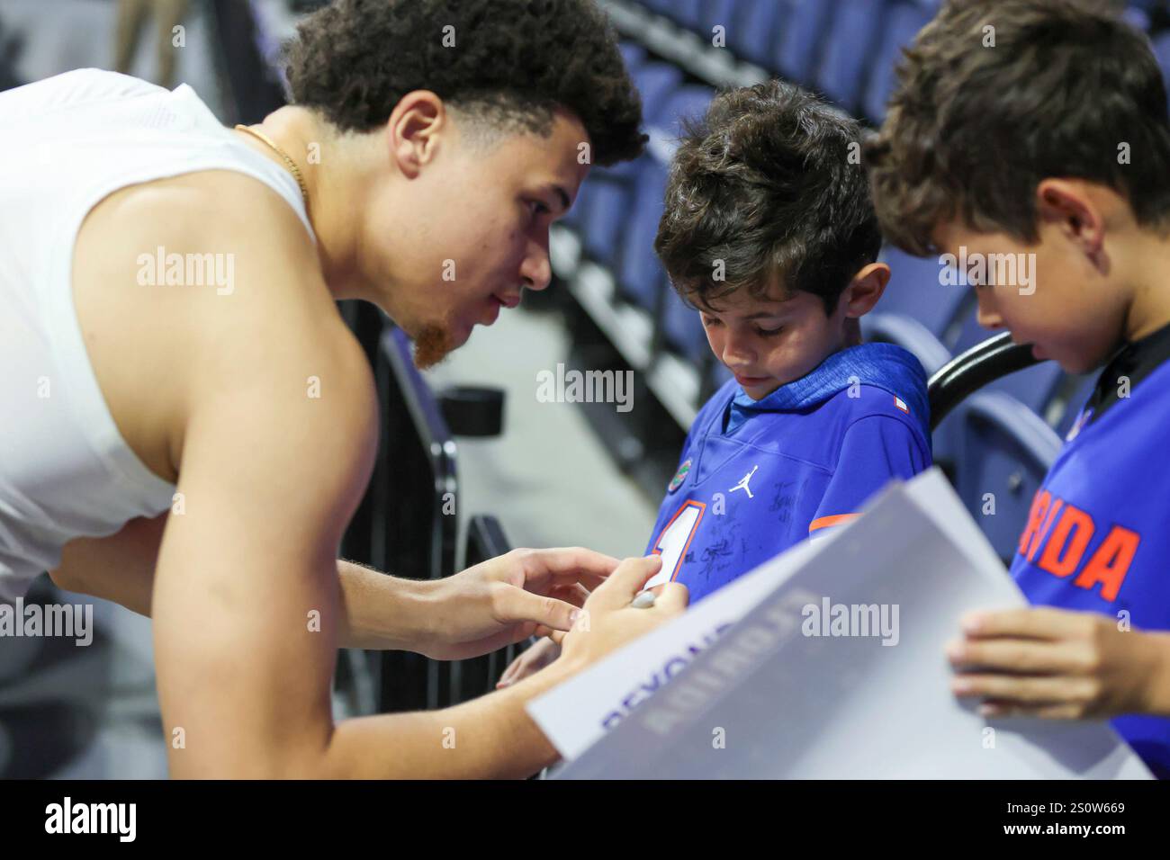 Florida guard Walter Clayton Jr., left, signs the jersey of Eli Fowler ...