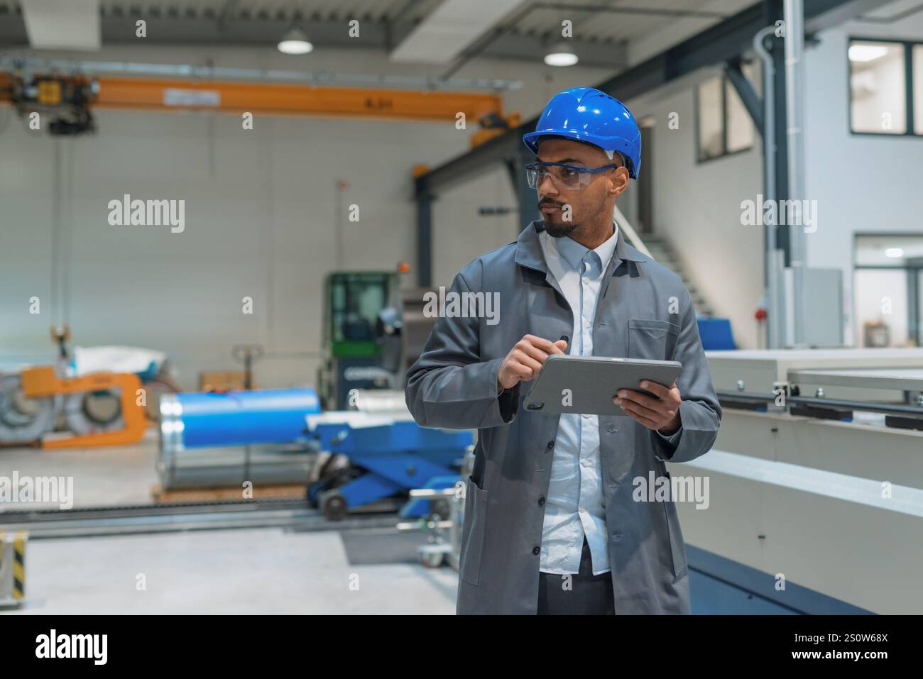 African American engineer with a blue helmet and safety goggles ...