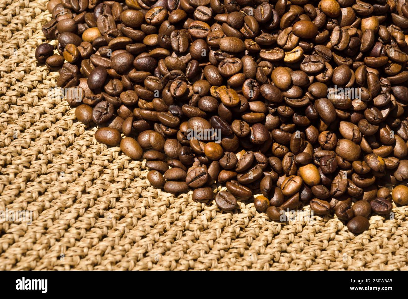 Roasted coffee beans on a knitted pattern in beige raffia. Hand knitted ...