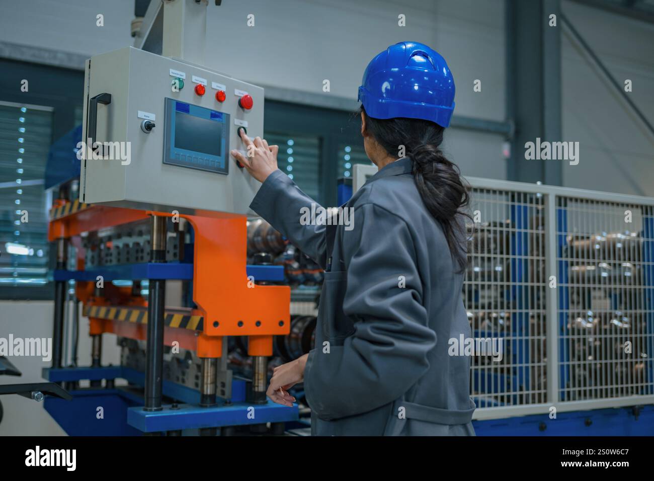 Indian woman engineer with a blue helmet and safety goggles, operating ...