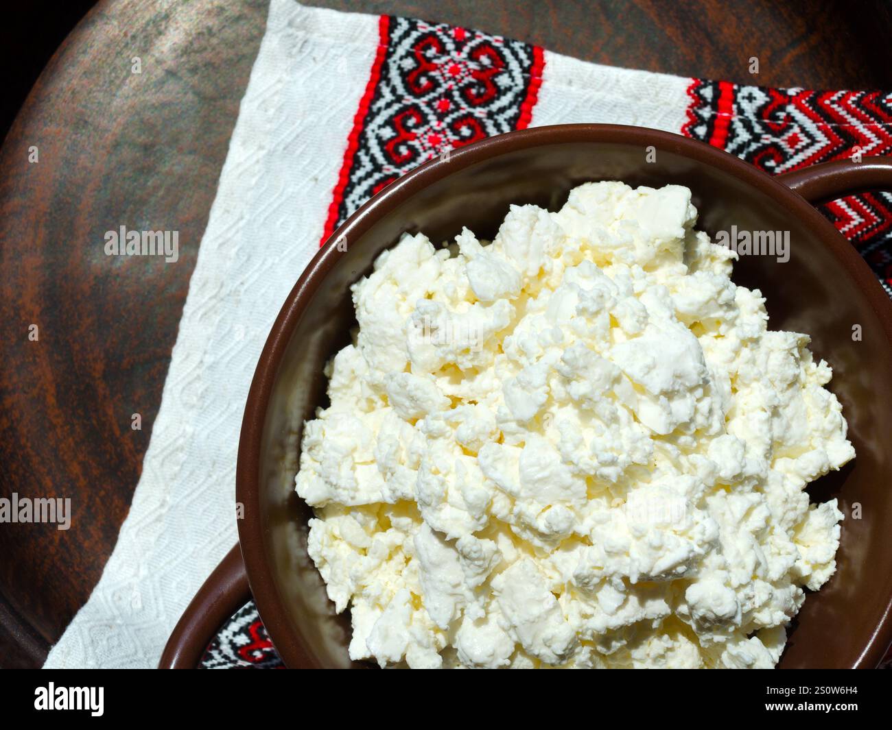 Cottage cheese in a ceramic bowl on the national Ukrainian vyshyvanka ...