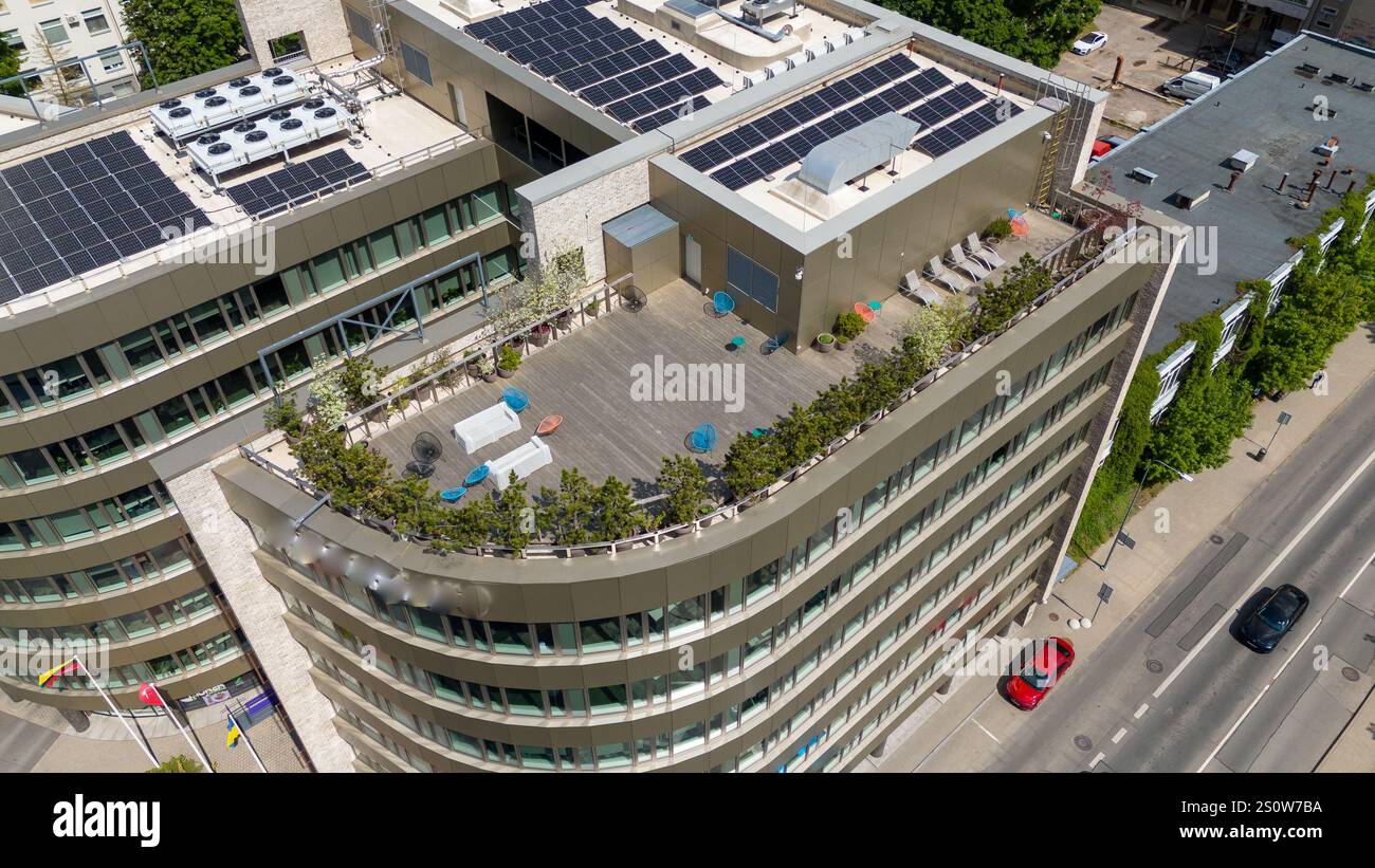 Aerial view of a modern building with a rooftop terrace featuring solar ...