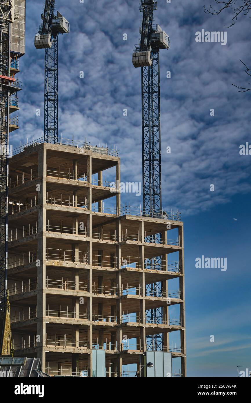 A partially constructed concrete building under a partly cloudy sky ...