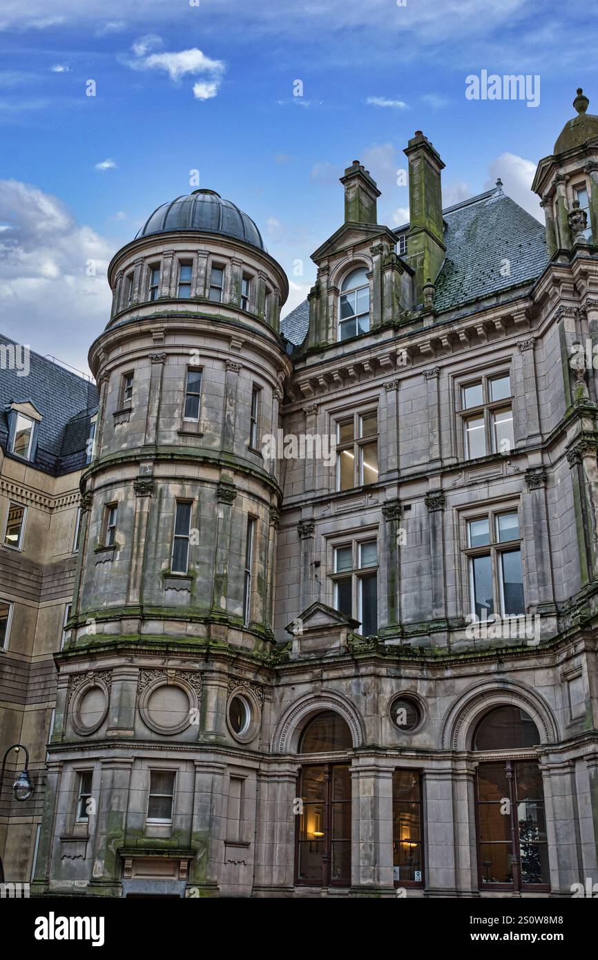 A grey stone building with a dome, multiple windows, and arched ...