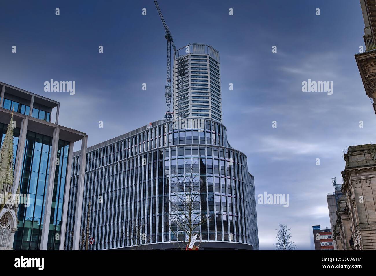 A modern glass and steel building under construction, partially ...