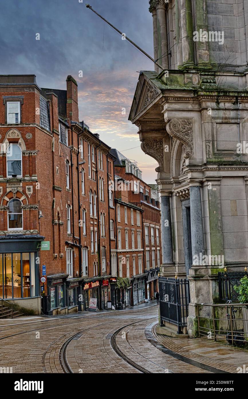 A curved street scene reveals a row of brick buildings and a portion of ...