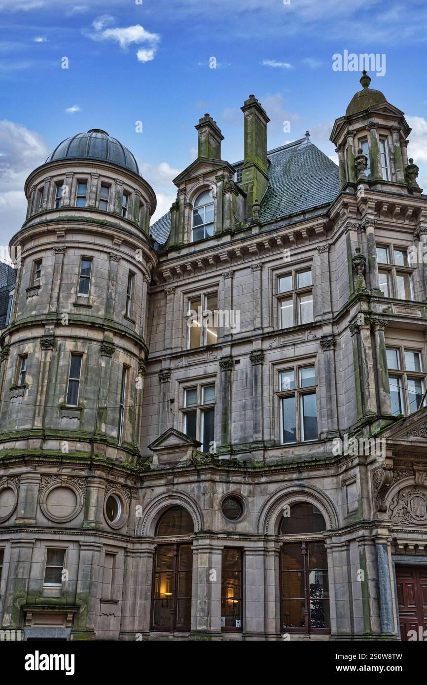A weathered, grey stone building with multiple towers, arched windows ...