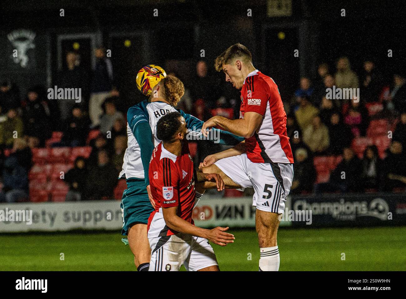 Morecambe FC's Hallam Hope is held by Stephen Negru of Salford City FC ...