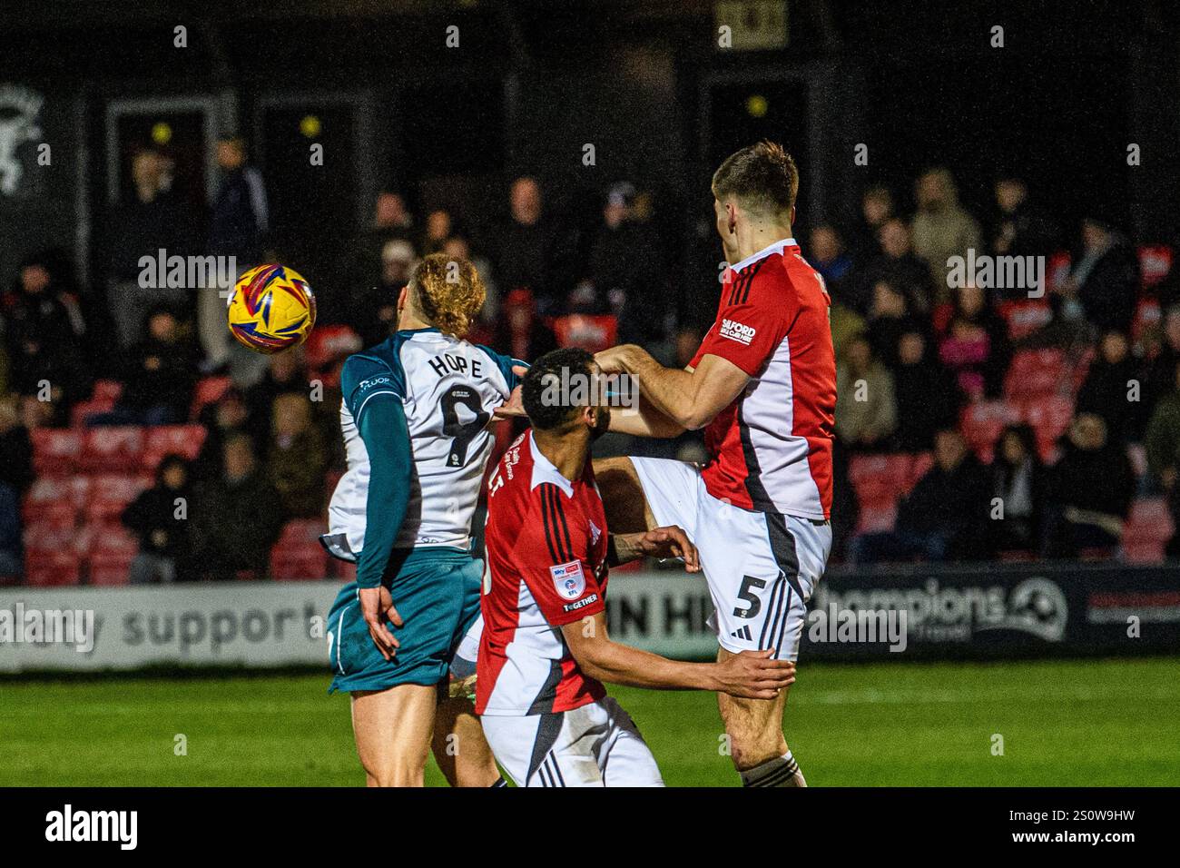 Morecambe FC's Hallam Hope is held by Stephen Negru of Salford City FC ...