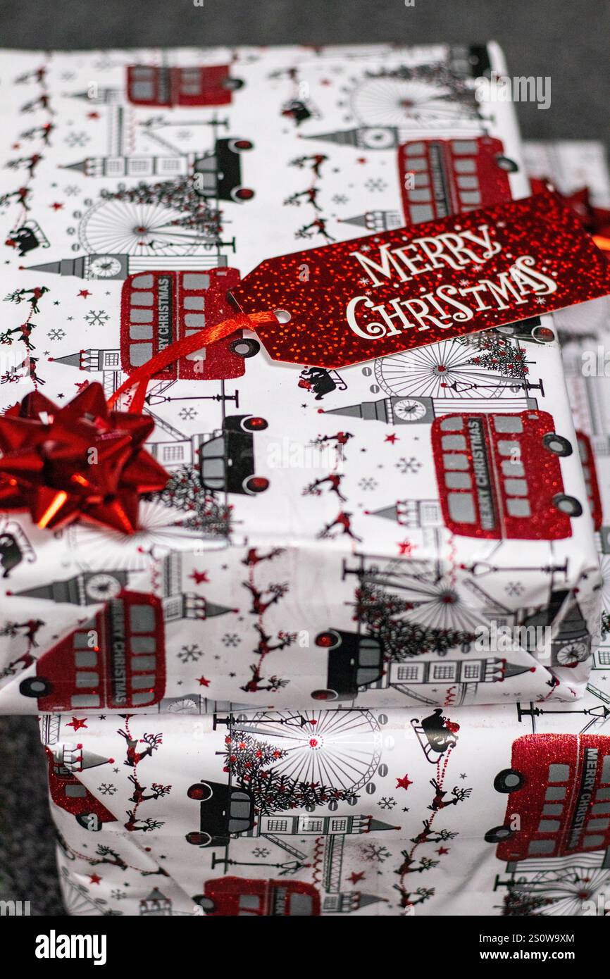 Two stacked Christmas gifts wrapped in white paper with a London-themed ...