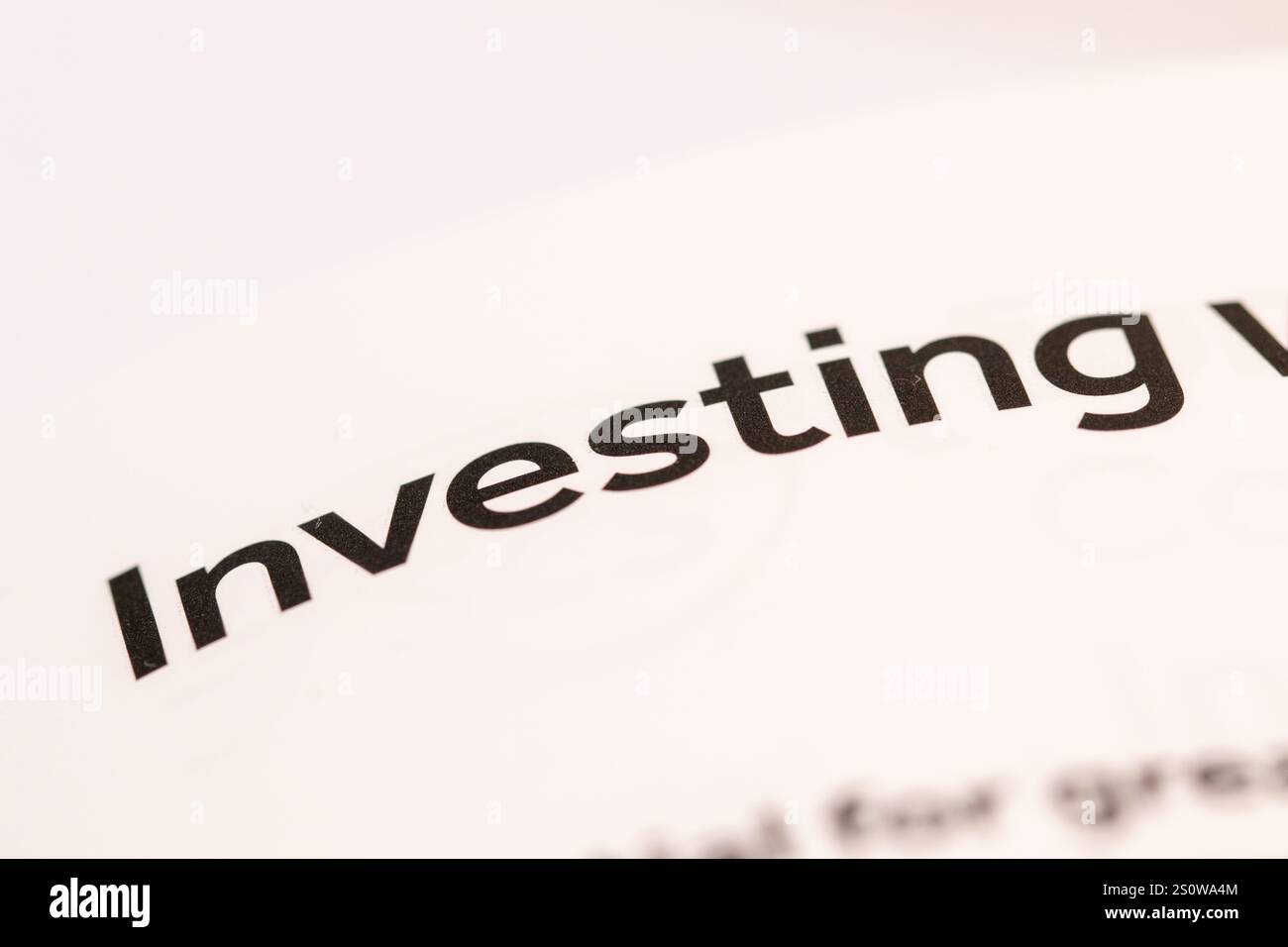 Close-up view of a white document with the word "Investing" prominently ...