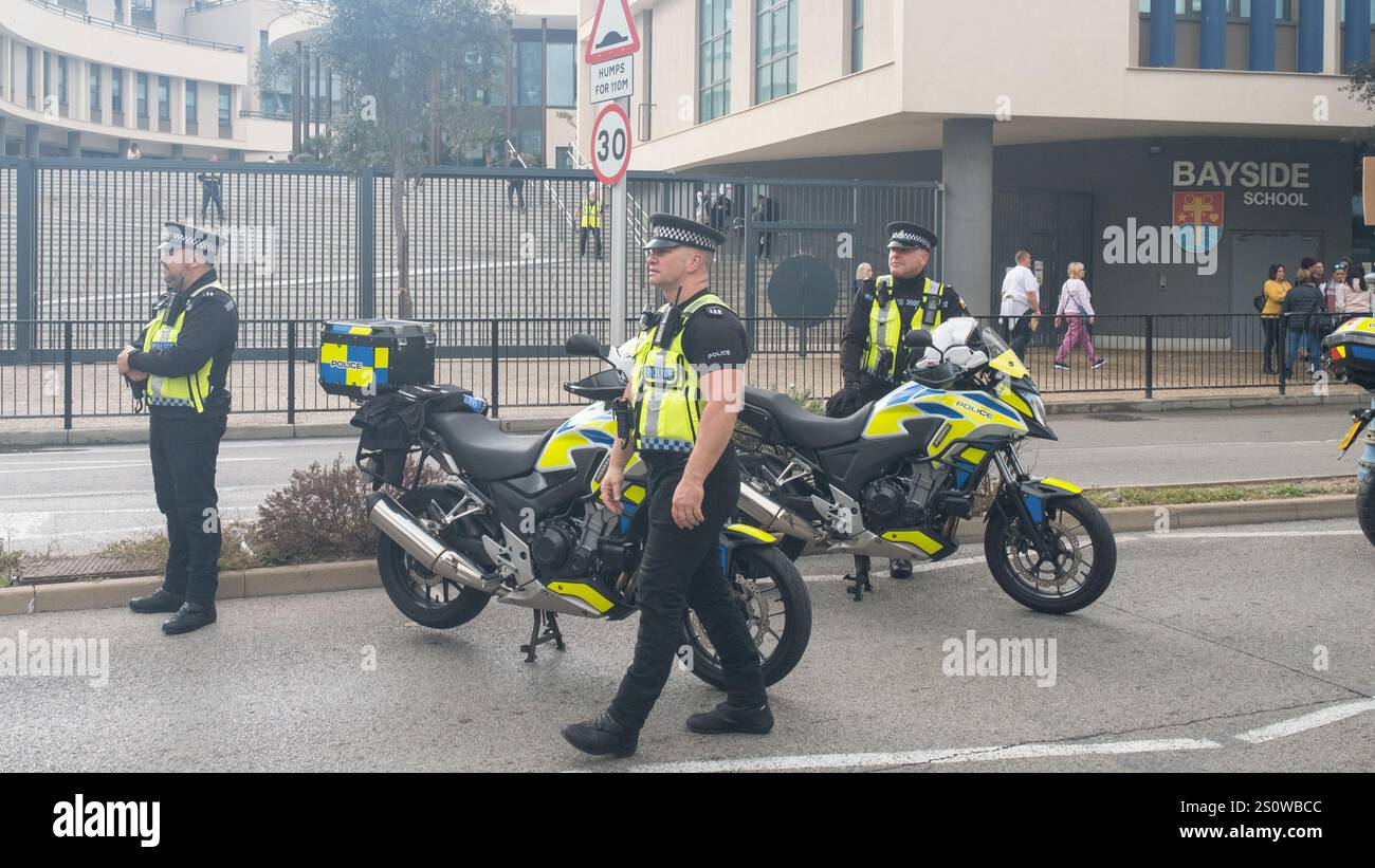 Police officers stand beside their motorbikes on a city street ...