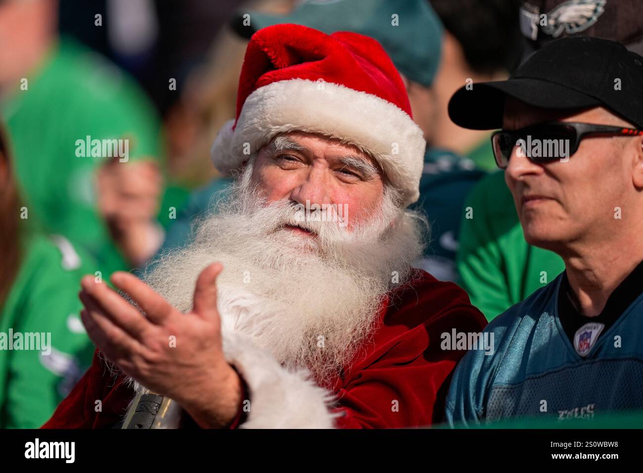 A spectator wearing a Santa Claus costume talks to a person during the ...