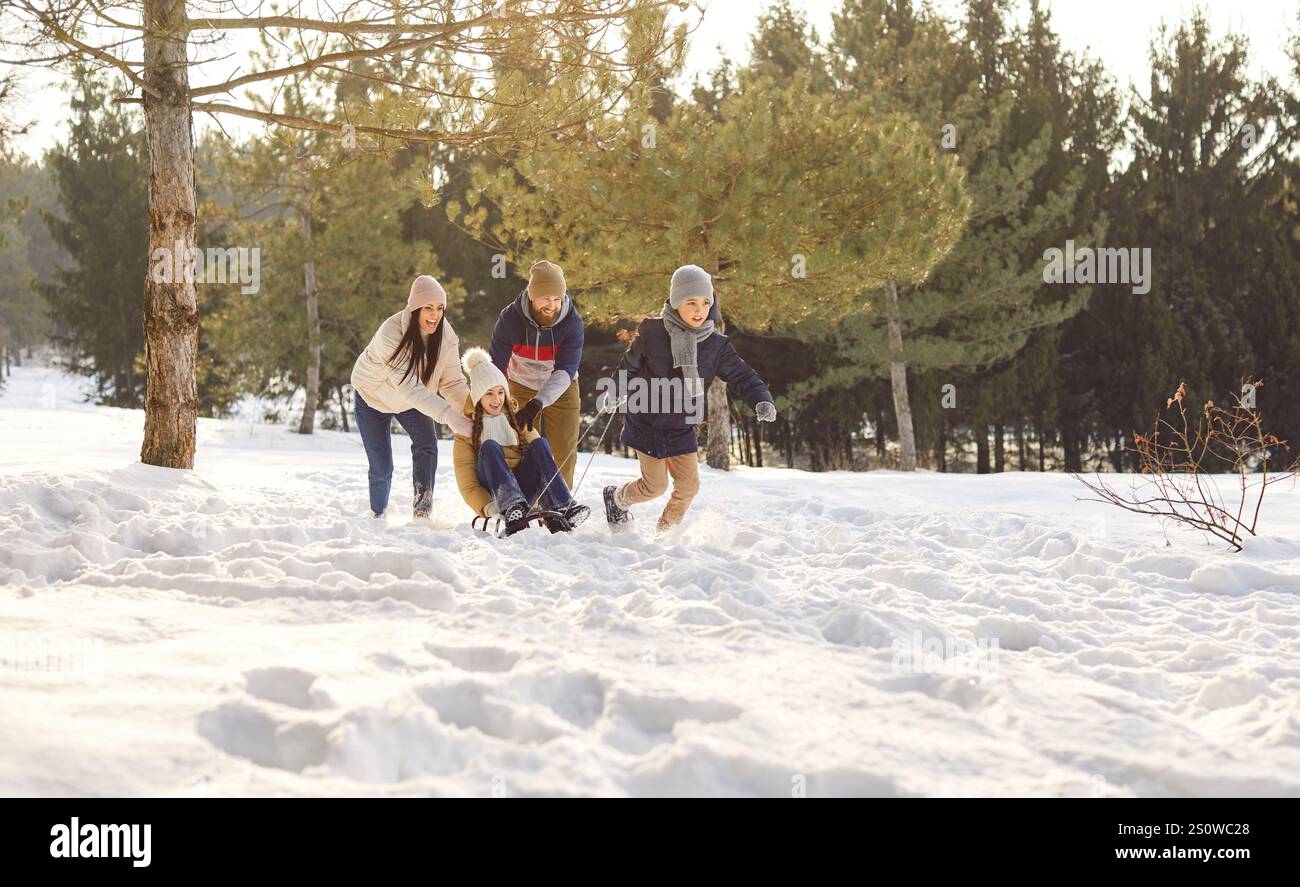 Happy family with kids having fun in winter park sledding together in ...