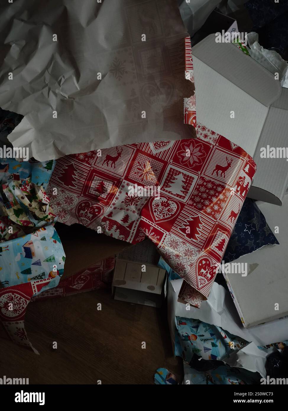Leftover christmas gift wrapping paper and boxes on the floor after ...