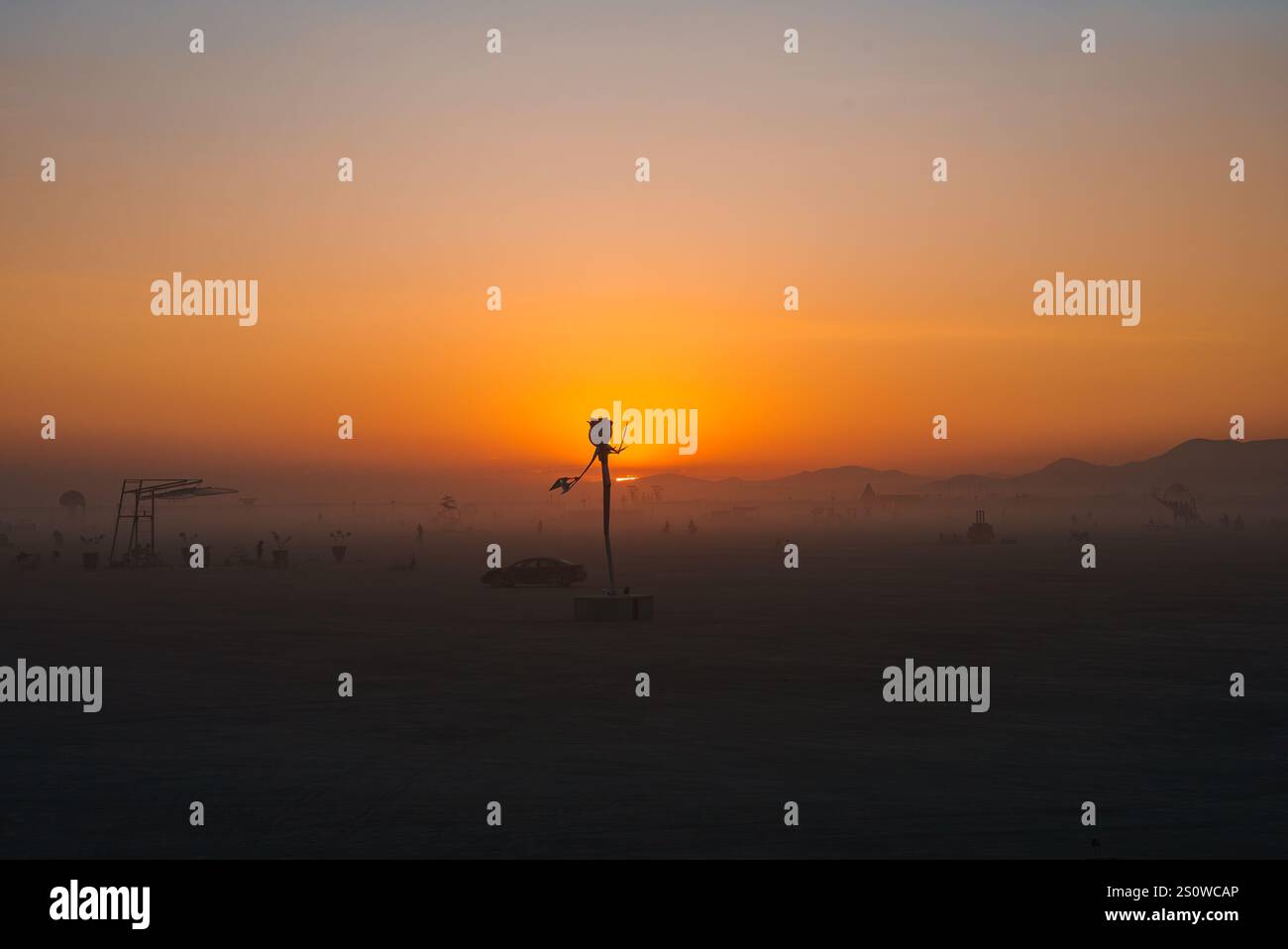 Sunset Over Desert with Silhouetted Art Installation at Burning Man ...