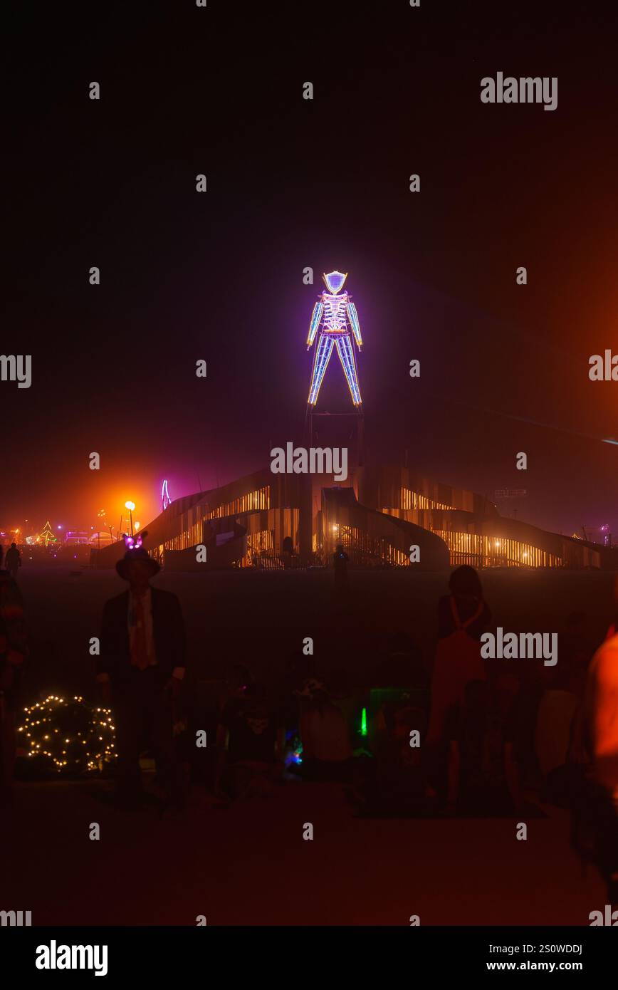A large illuminated humanoid sculpture known as The Man stands elevated ...