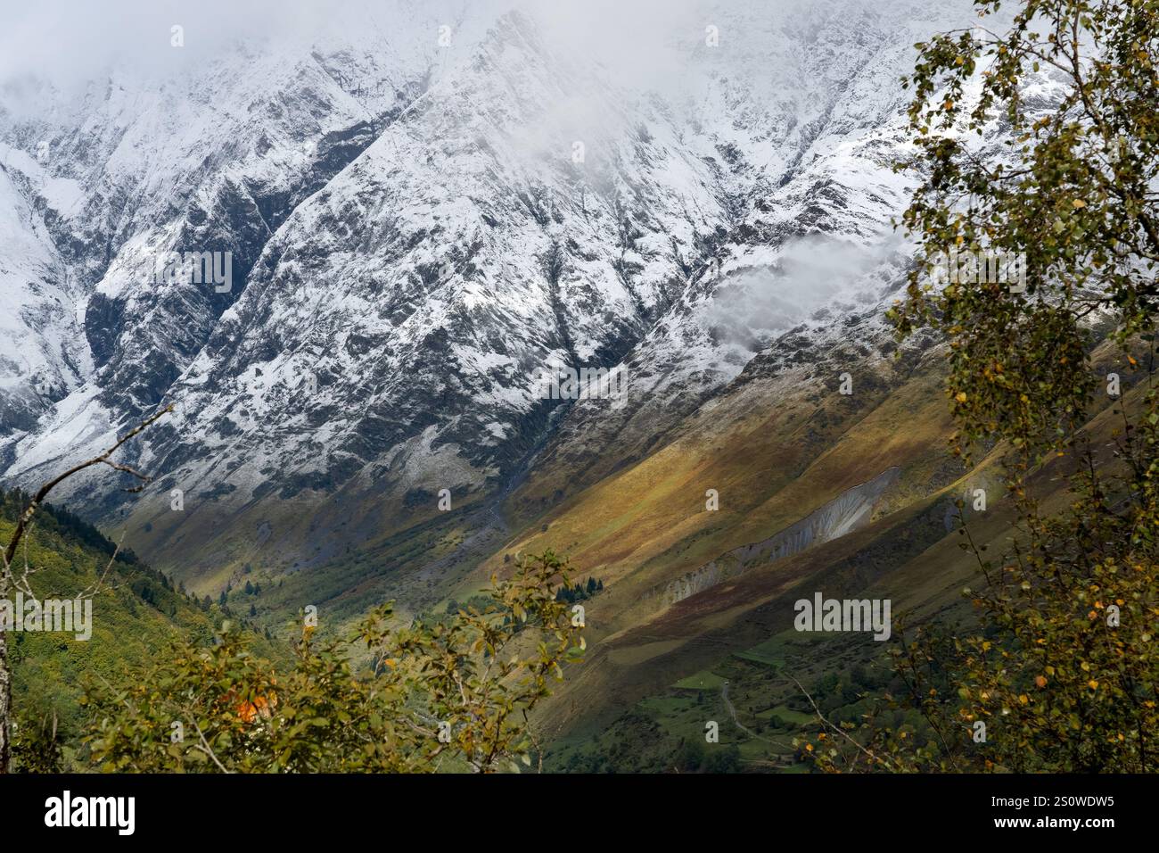 magnificent view of a long glacial valley through snow and cloud topped ...