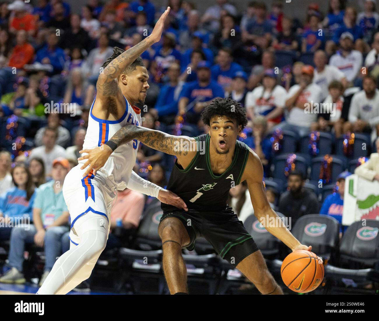 Stetson forward Josh Massey (1) drives on Florida guard Will Richard ...