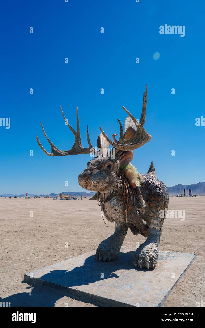 A large jackalope sculpture with antelope like horns stands in a desert ...