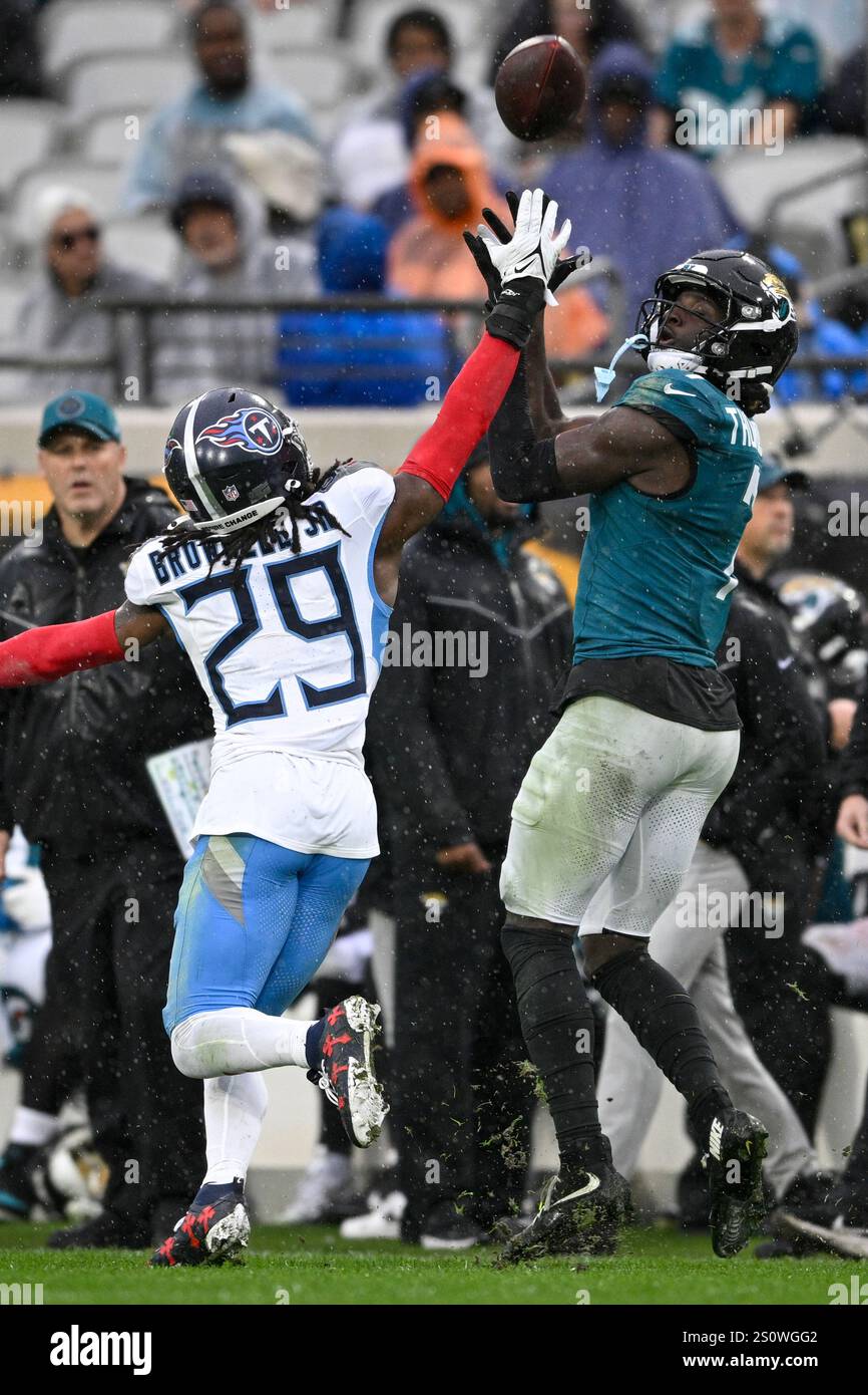Jacksonville Jaguars wide receiver Brian Thomas Jr., right, makes a catch over Tennessee Titans ...