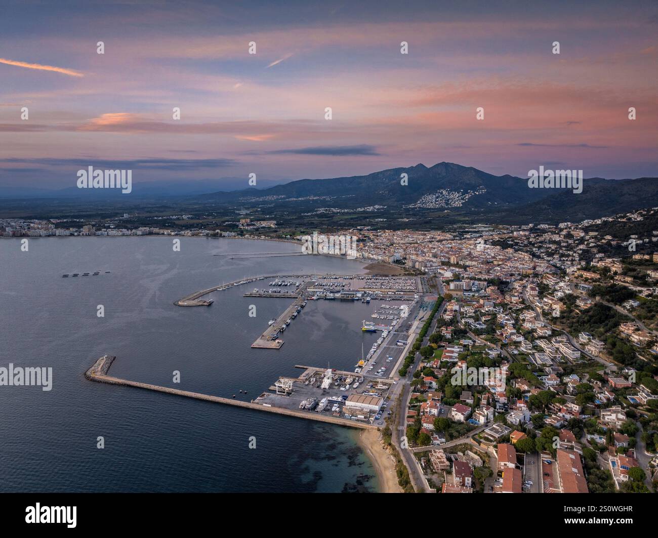 Aerial view of the city and harbour of Roses at a reddish sunset (Alt ...